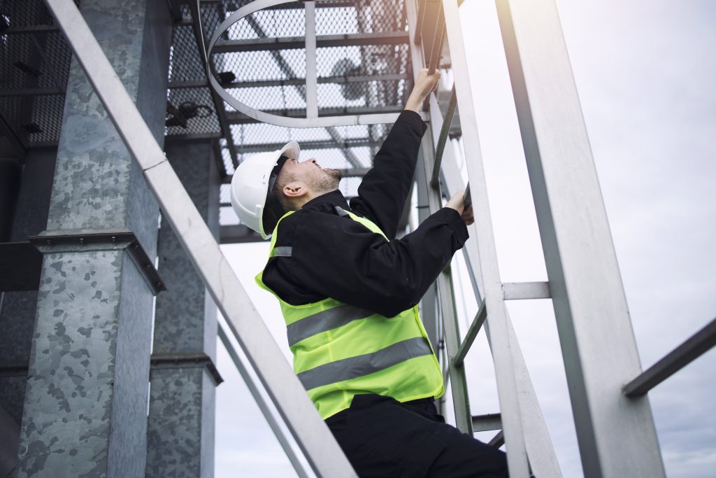 Industrial factory construction worker climbing metal ladder of ...